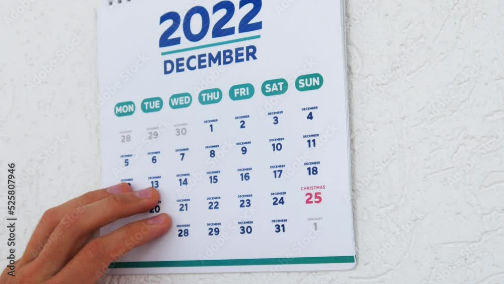 Zooming in of two male hands tearing off the wall calendar page 2022 ...