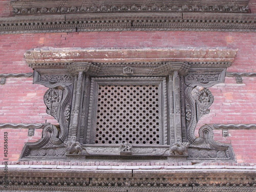Kathmandu, Nepal, August 20, 2011: Wooden lattice window in a red brick ...