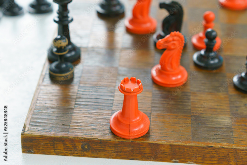 Old wooden chess board with red and black chess pieces. Rook. Position ...