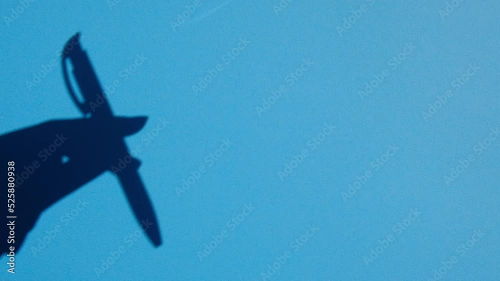 shadow hand twists the handle on a blue background, free space. Sign ...