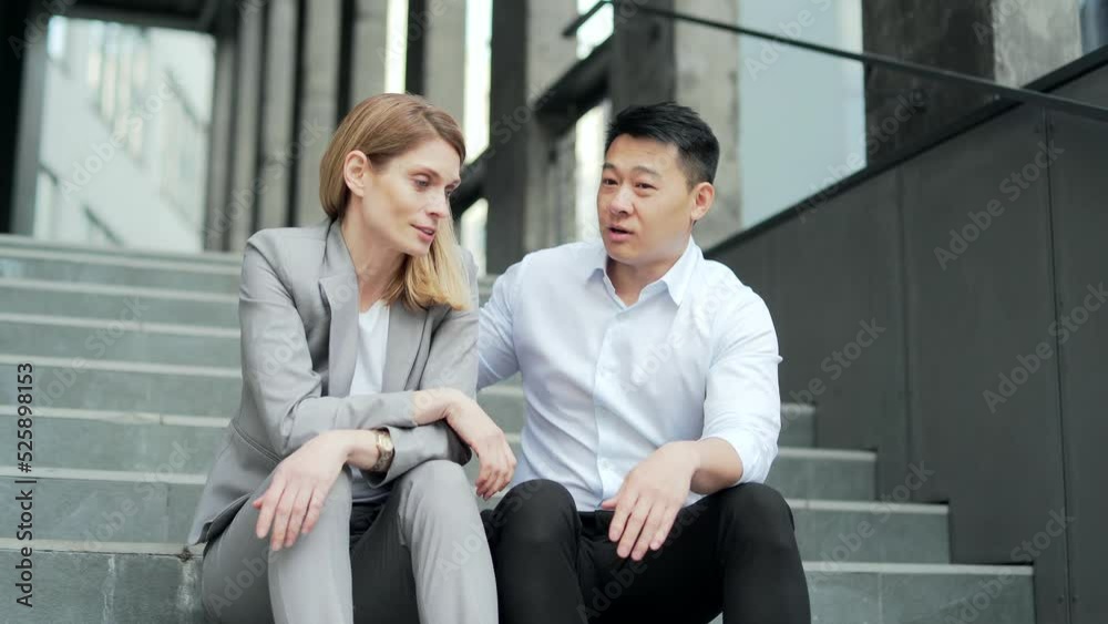 Asian male employee supports upset depressed female co-worker colleague ...