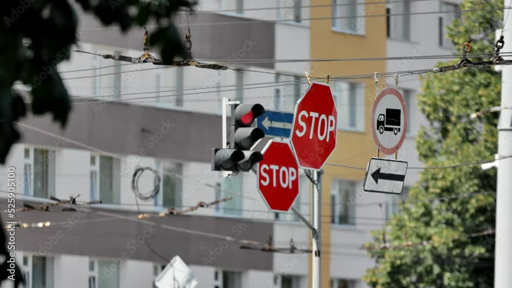 Traffic light and road signs on the background of city buildings. The ...