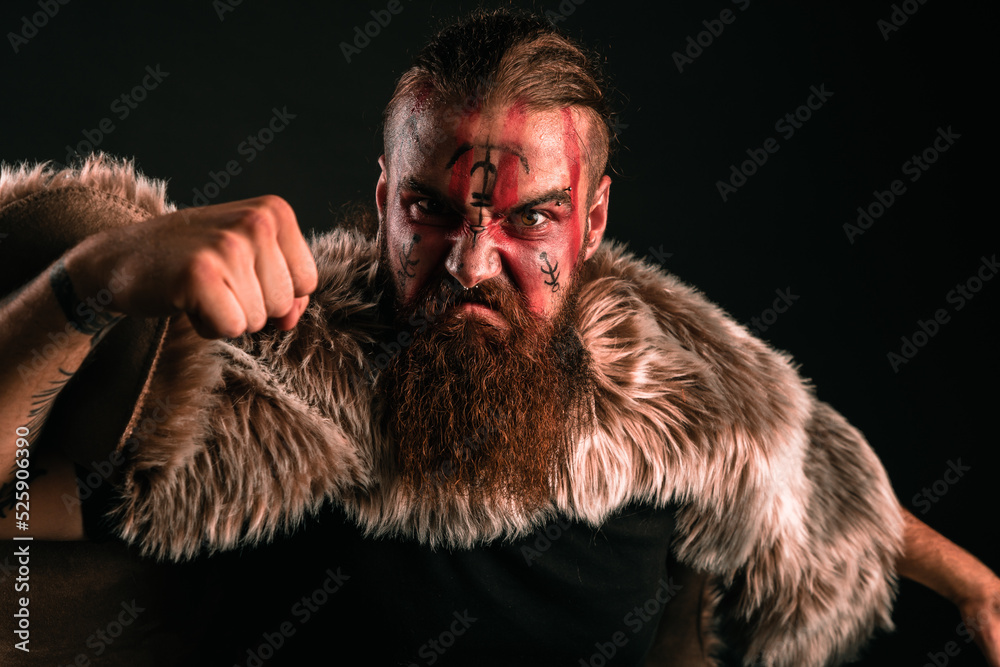 Angry Viking warrior with war paint, attacking his foe in anger and ...