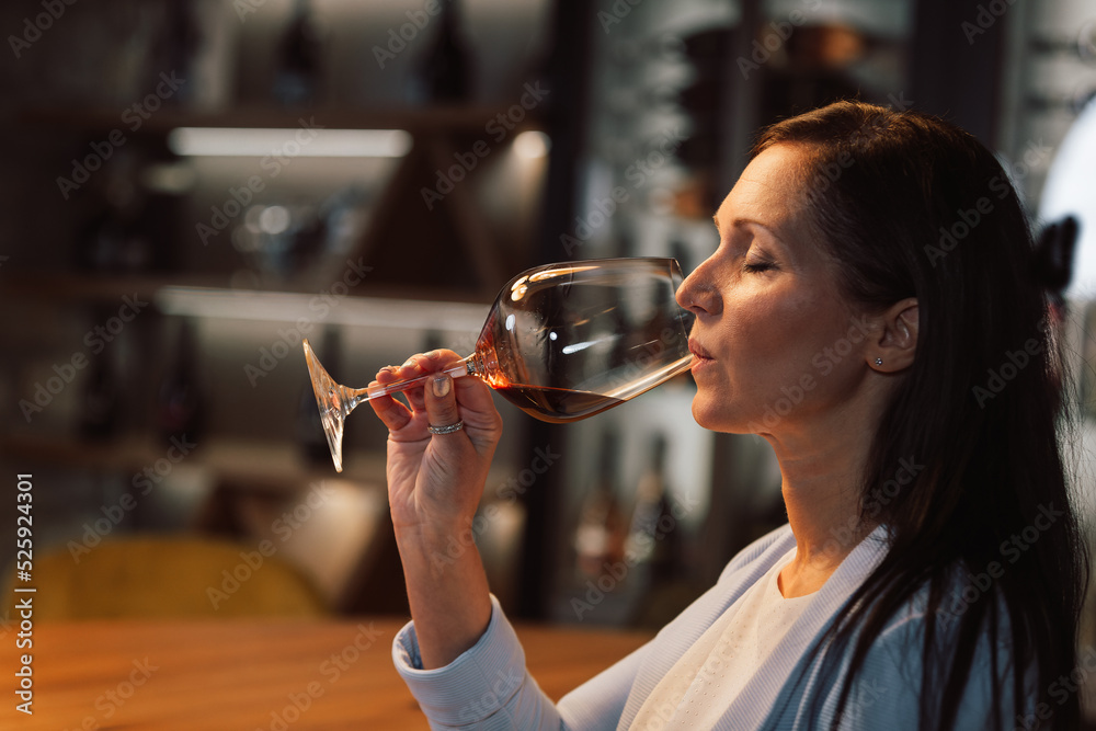 Woman tasting wine at the wine cellar with barrels in background Stock ...