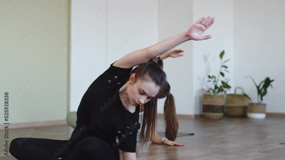 Healthy white girl wearing black clothes doing stretching exercise in ...
