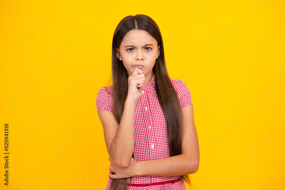 Smart nerdy school girl touching cheek and thinking against yellow ...