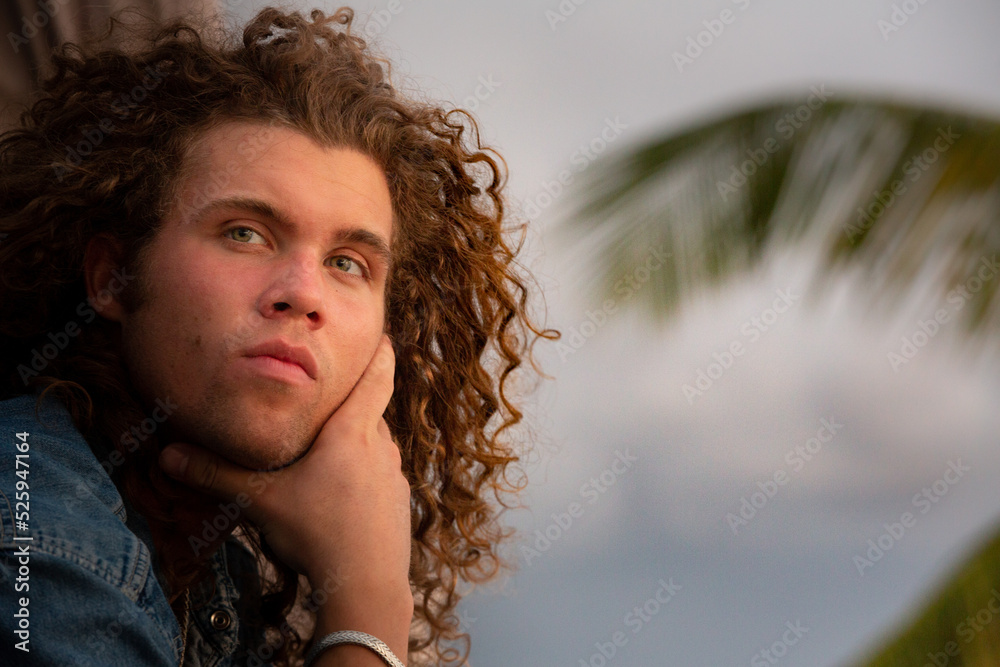 Moody male with flowing hair in sunset tropics Stock Photo | Adobe Stock