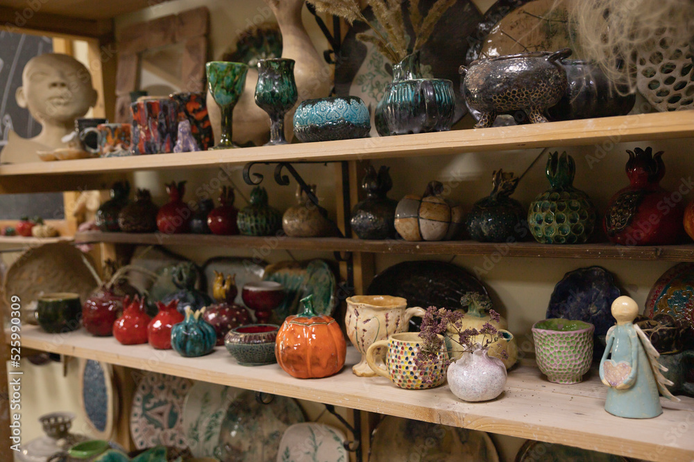 Shelves with finished handmade ceramic dishes in various shapes and ...