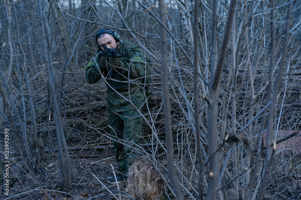 soldier in the forest. a man in military uniform in the branches of ...