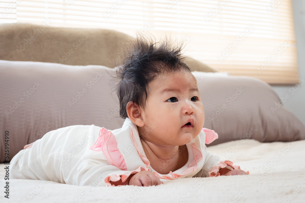 Close Up Asian girl lying face down in bed in her bedroom, after waking ...