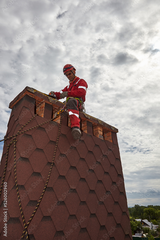 Foto de A specialist is repairing the roof. Rope access do Stock ...