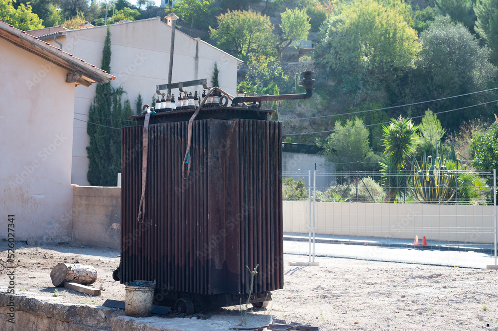 Detail of a very large old electrical transformer that has wheels for ...