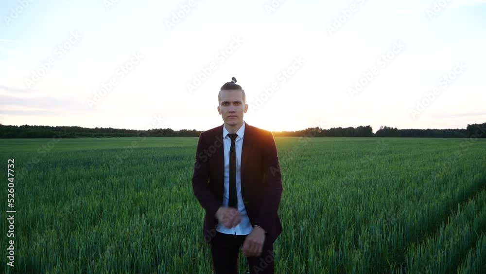 Guy In Suit Straightens His Tie And Looks At The Camera In The Middle
