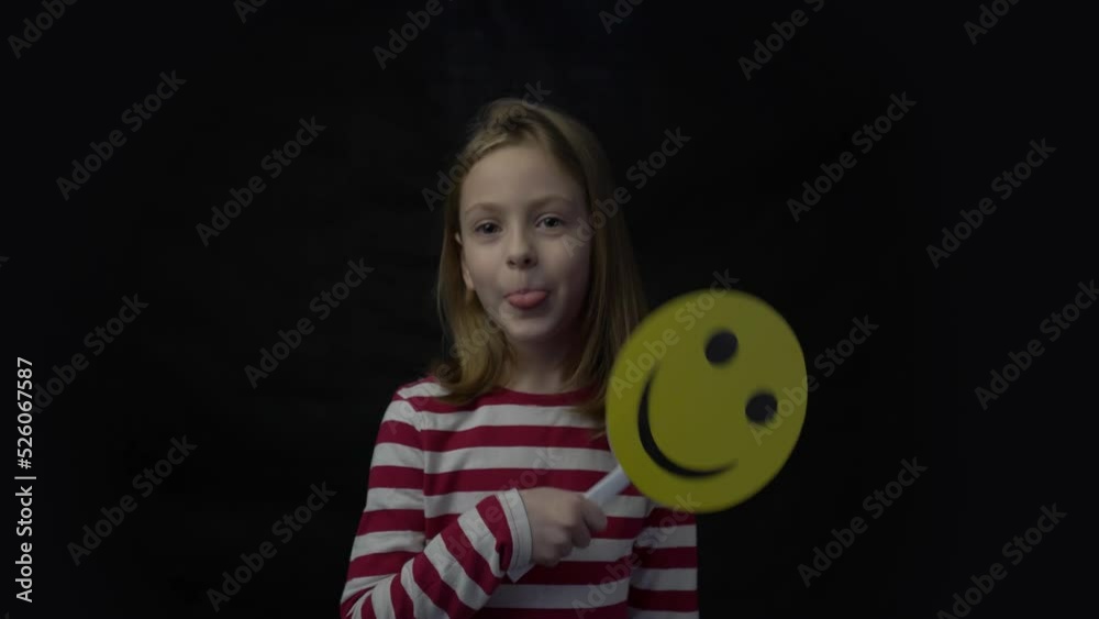 4k Female expressing happiness with smiling emoji mask and turn to ...