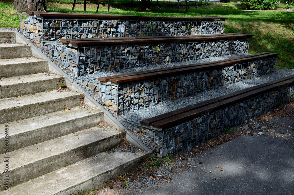 grandstand in the park by a concrete staircase made of gabion baskets ...