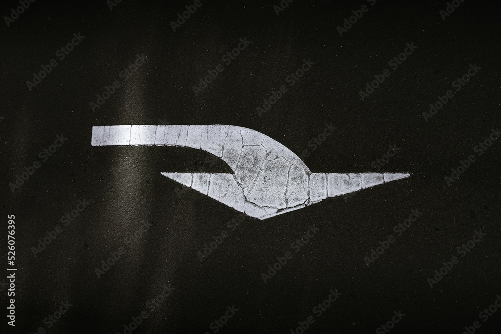 Curved Arrow road sign painted on bitumen asphalt road in white paint ...