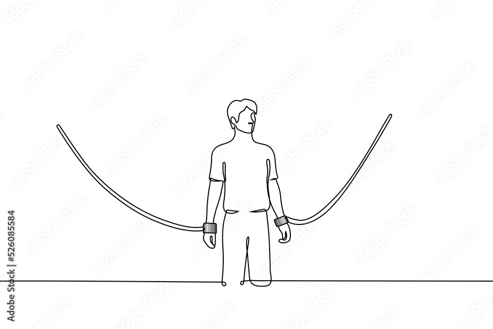 man stands captive by huge handcuffs against the walls - one line ...