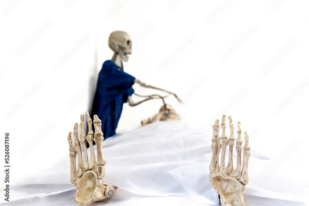 View from patients feet, skeleton doctor wearing blue scrubs uses ...