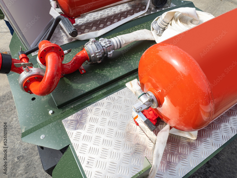 Fire-fighting equipment. Red cylinder and fire hose are located side by ...