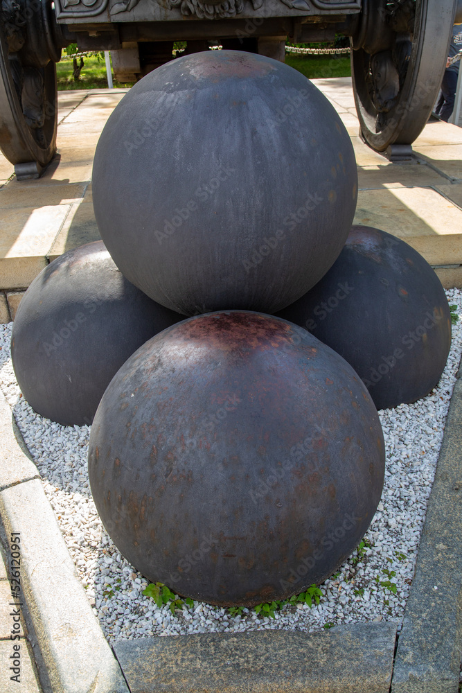 Cast-iron cores stacked in a pyramid of black color on a pedestal ...