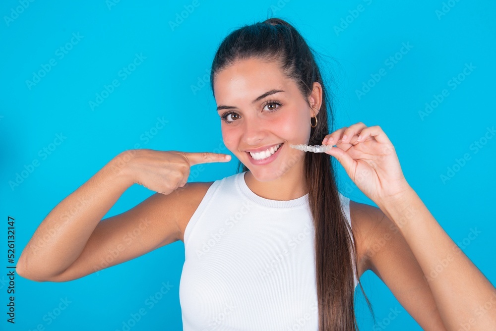 Beautiful Brunette Woman Wearing White Tank Top Over Blue Background