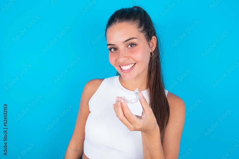 Beautiful Brunette Woman Wearing White Tank Top Over Blue Background