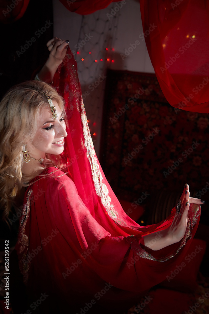A beautiful European girl looking like an Arab woman in a red room in a ...