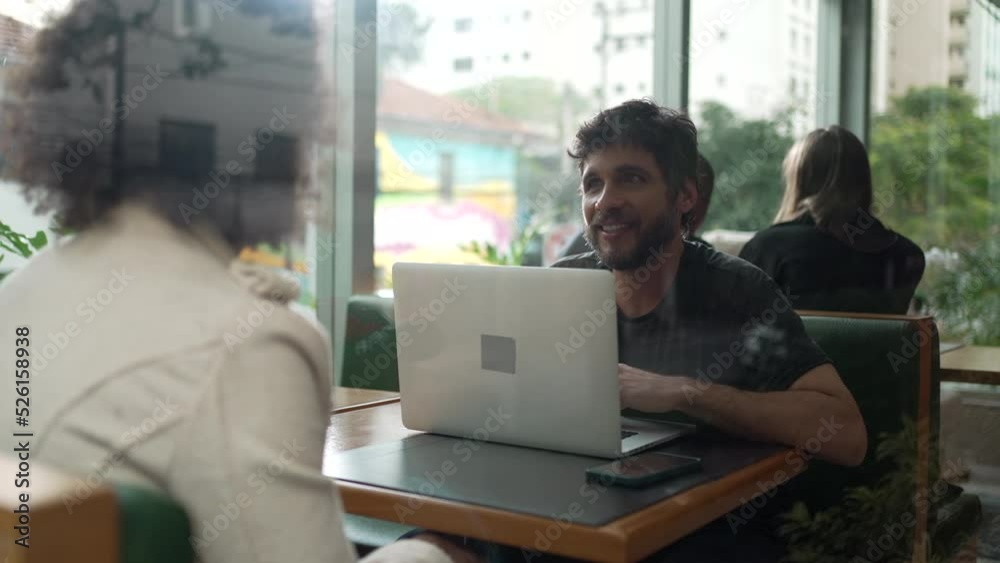 People inside coffee shop through glass window. Men and women customers ...