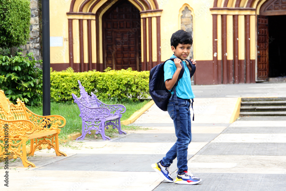 Stockfoto Poor dark-haired 8-year-old Latin boy walks down the street ...