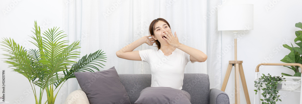 Beautiful Asian woman sits lazily on the sofa, Preparing to sleep ...