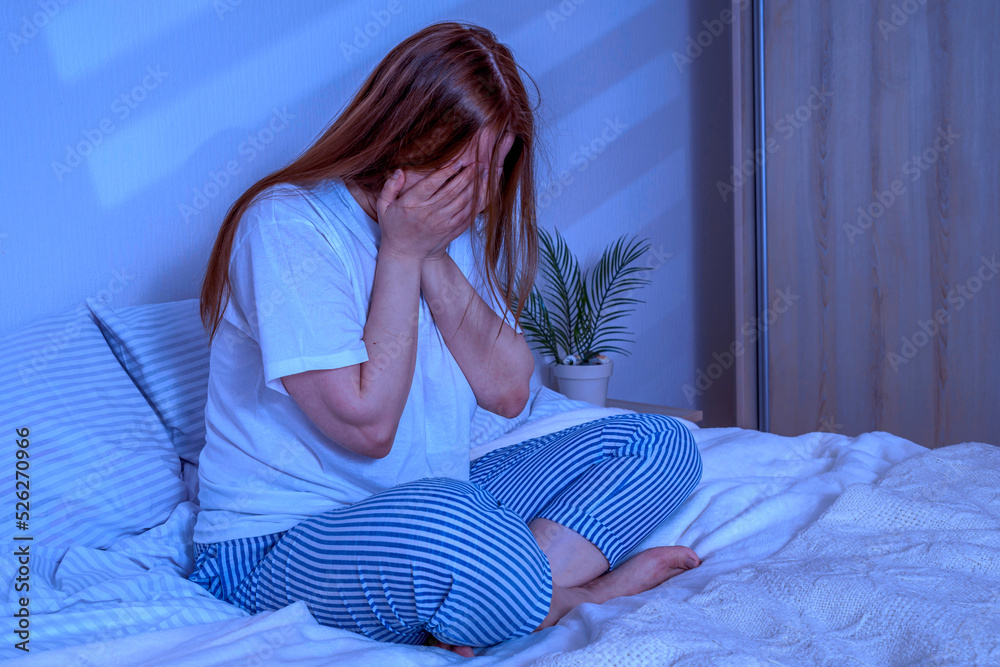 Woman sad crying in bed at home in the morning. Lady with long hair in ...