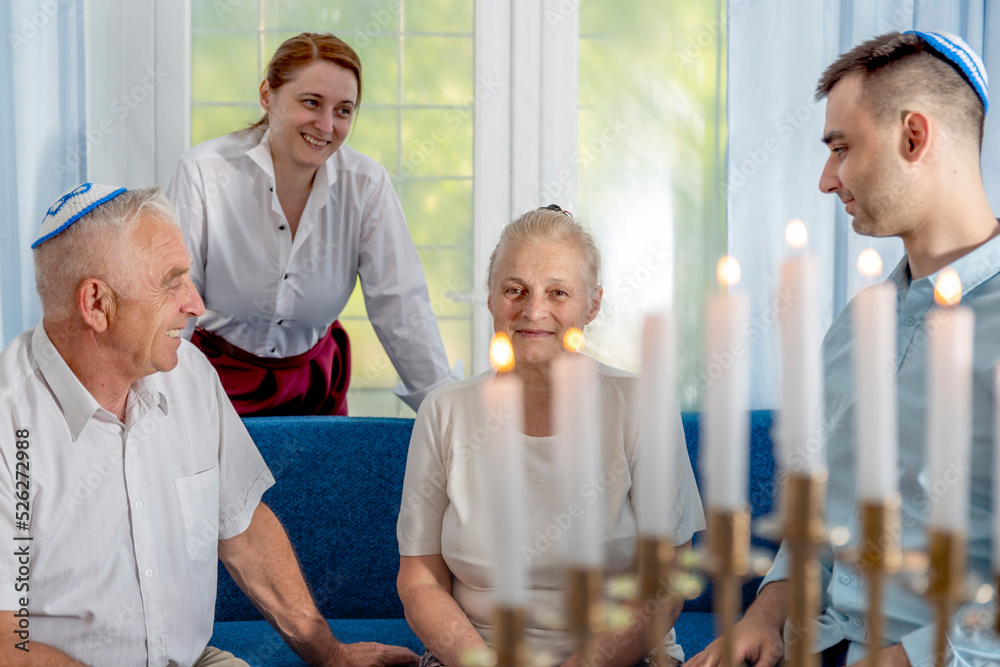 Jewish family celebrates Hanukkah. A senior man and young guy wear ...