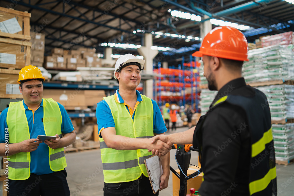 Industrial warehouse worker or engineer in safety suite handshake ...