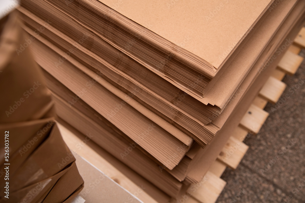 Sheets of kraft paper lie in large piles, acclimatize, dry before being ...