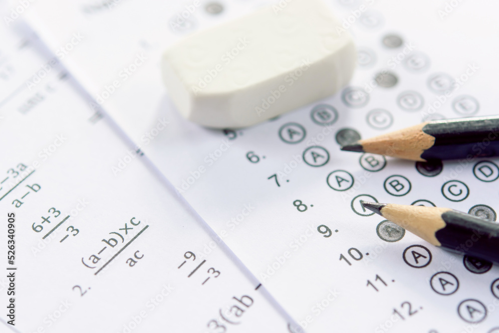 Pencil and eraser on answer sheets or Standardized test form with ...