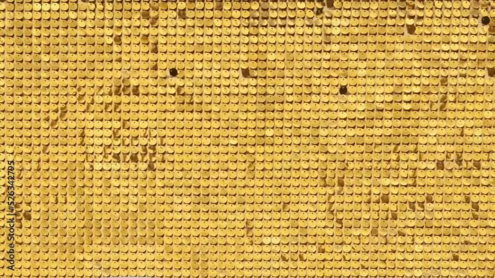 rows of blinking golden yellow brass metal plaques sway in wind and ...