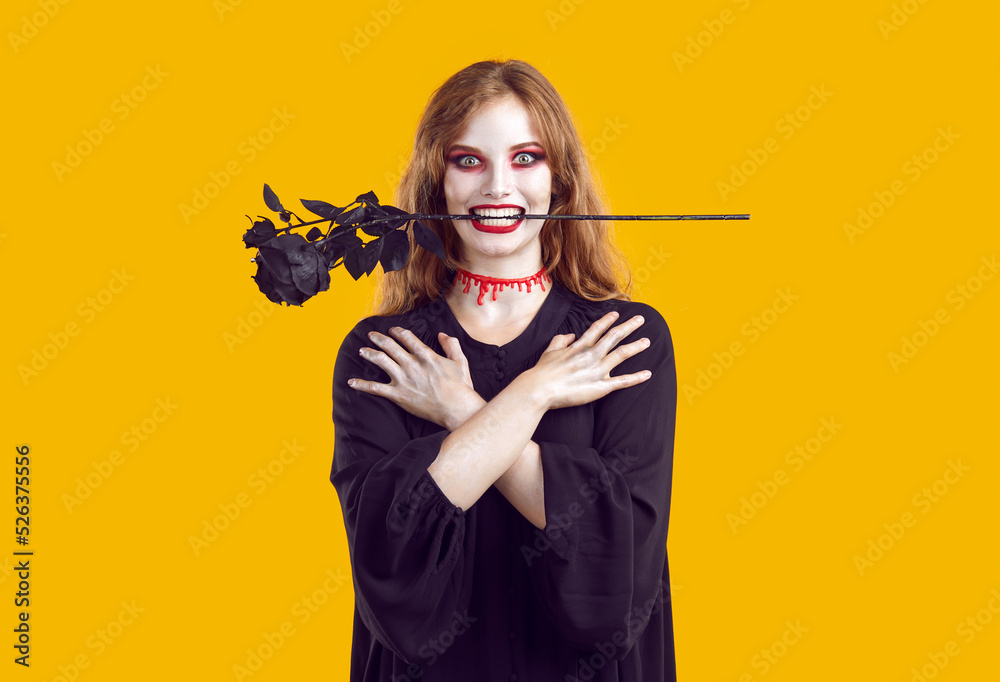 Smiling scary woman with black rose in her teeth, crossed arms on chest ...