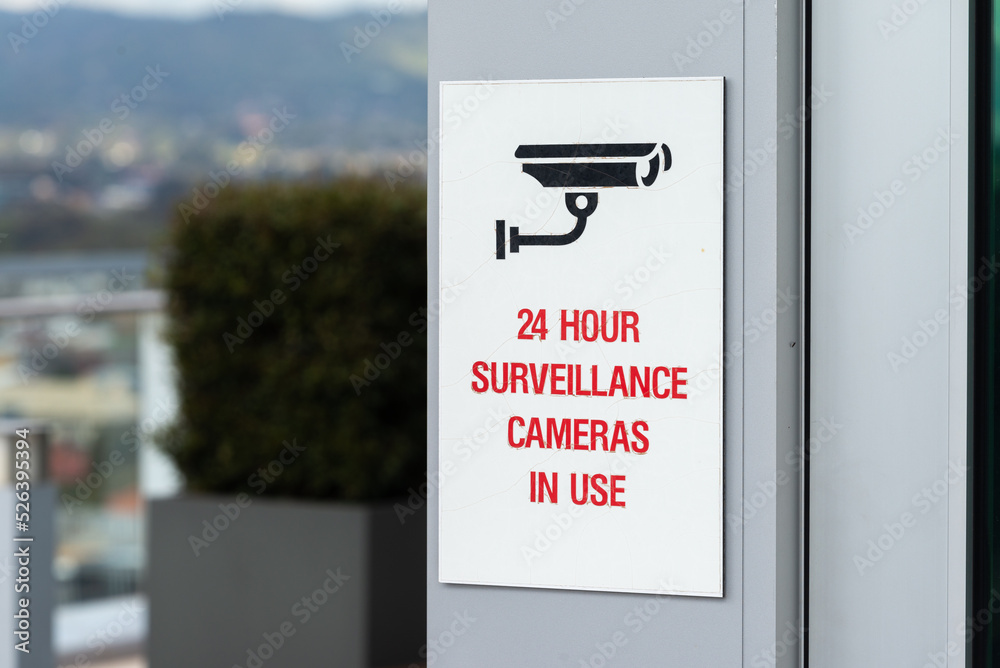 24 hour surveillance cameras in use security warning sign on blurred ...