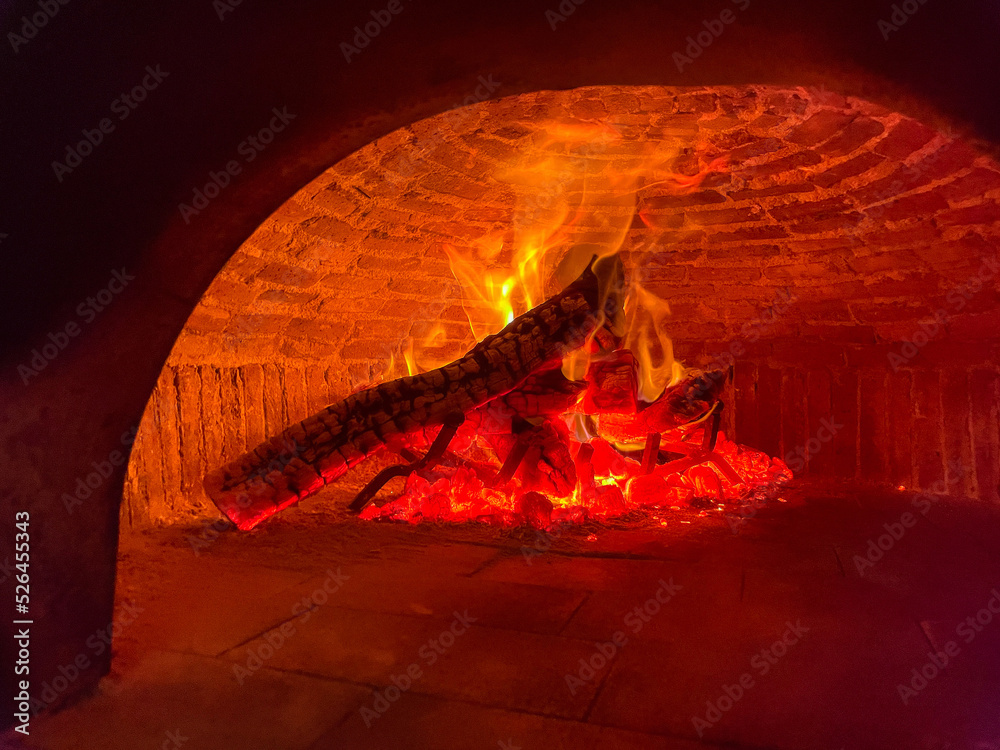 Wood burns in a traditional wood-burning oven of an Italian pizzeria ...