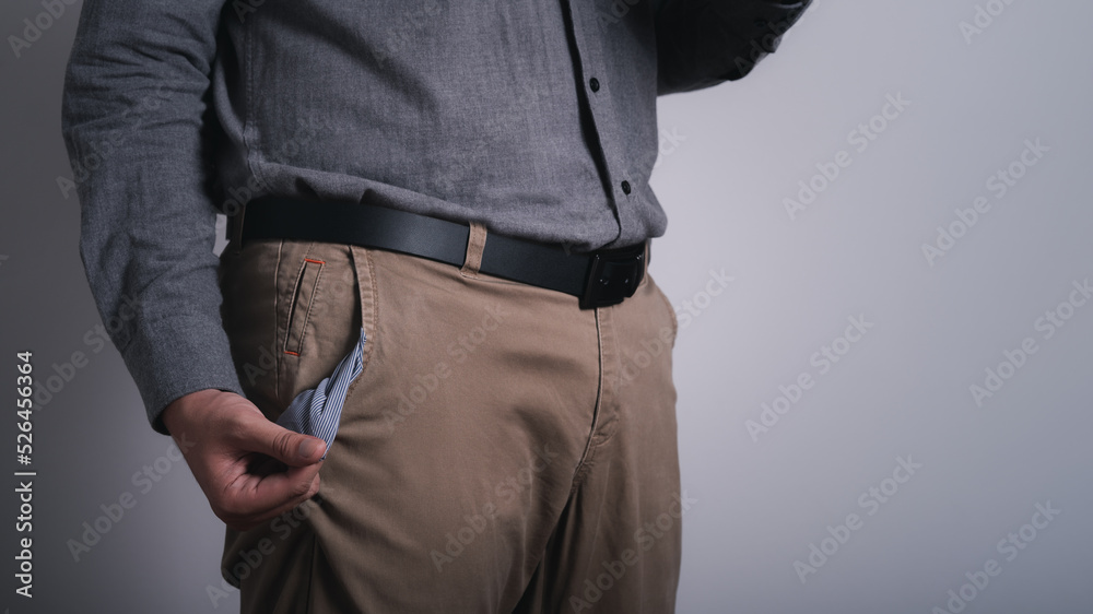 Poor businessman hand holding and showing his empty pocket money with ...