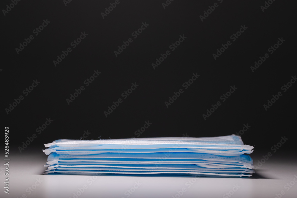 A stack of surgical mask with spotlight effect in isolated black ...
