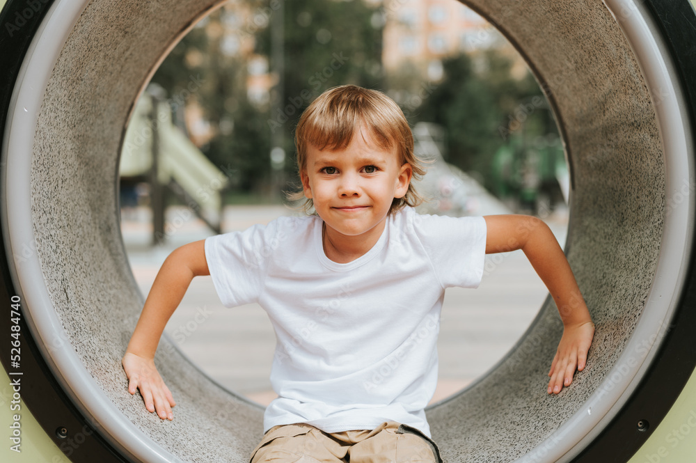 Stockfoto kid playing on the city playground on ring around. cute little happy smiling candid ...