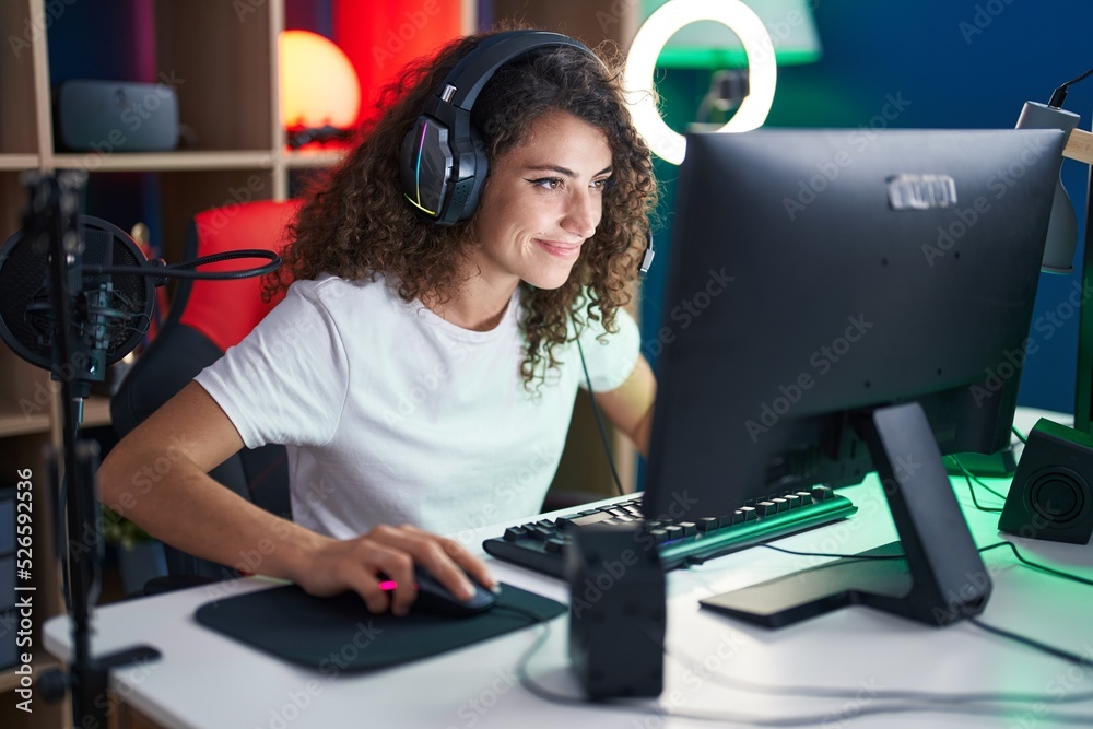 Young beautiful hispanic woman streamer playing video game using ...