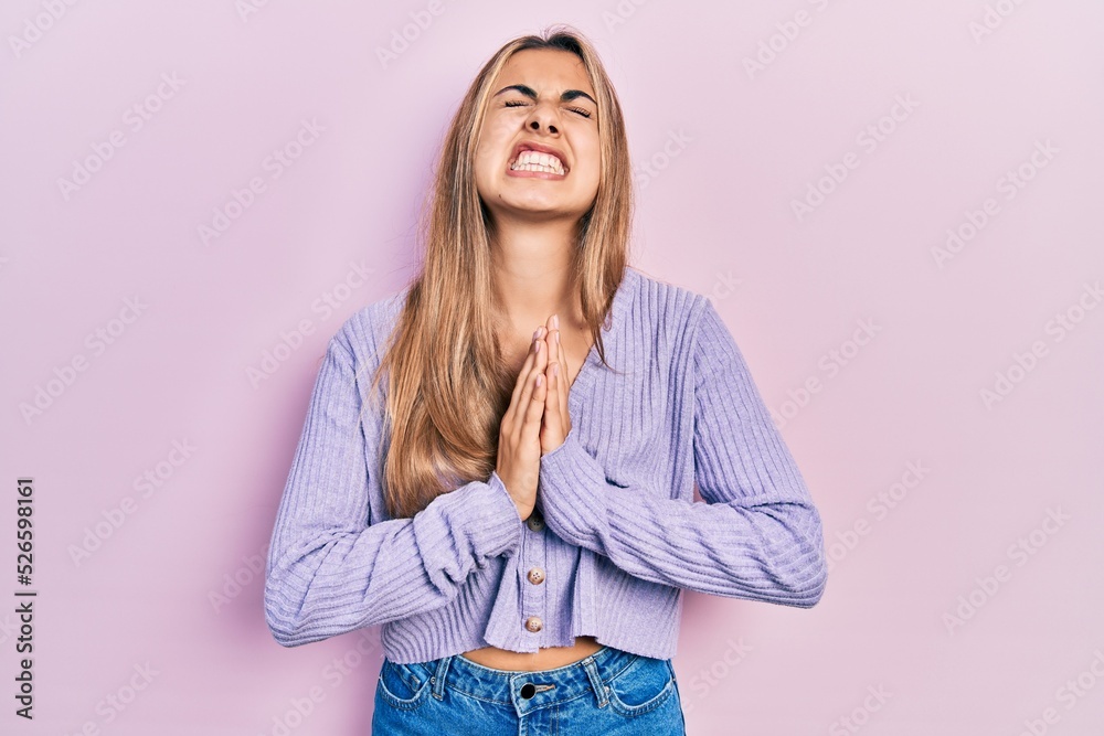 Beautiful hispanic woman wearing casual shirt begging and praying with ...