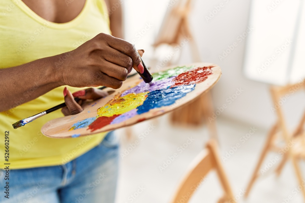 African american artist woman mixing color on palette at art studio ...