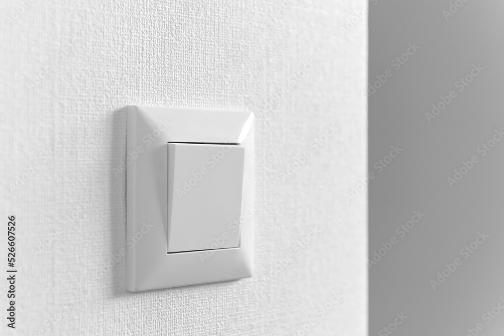 Foto de White electrical plastic switch on an isolated renovated wall ...