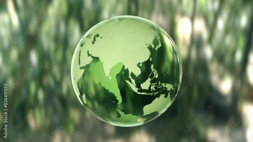 4k Rotating planet Earth shaped ball made of crystal in a green forest ...