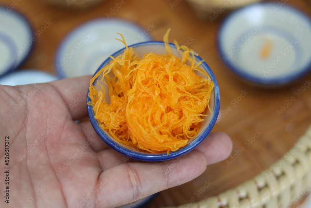 Hand holding Golden Threads recipe (Foi Thong in Thai language). Sweet ...