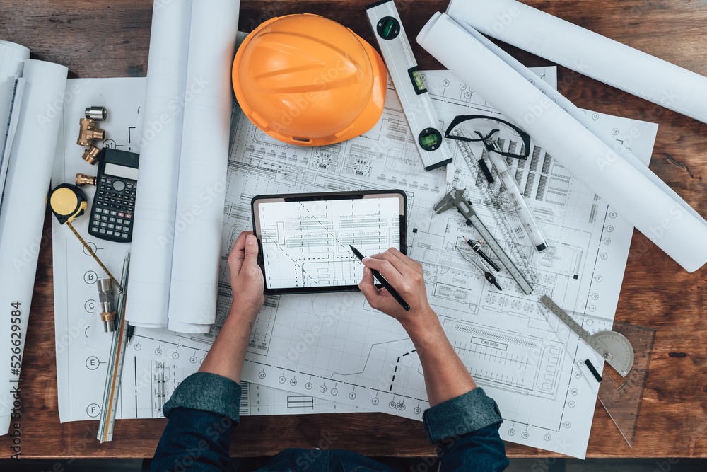 Engineering working with drawings inspection on tablet in the office ...