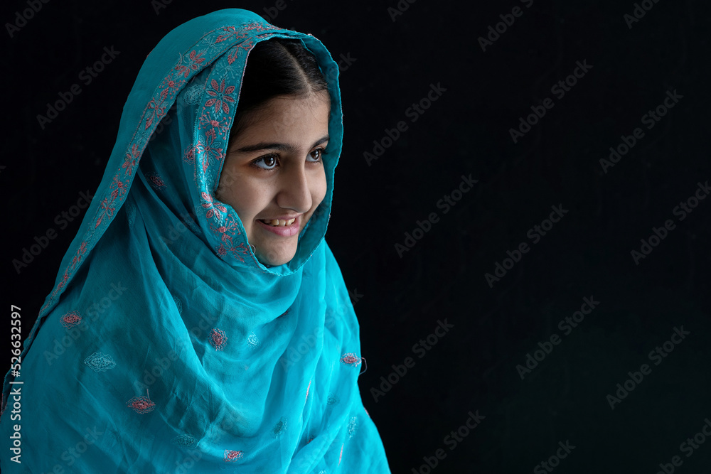 Little Muslim girl with beautiful eyes wearing blue hijab smiling with ...